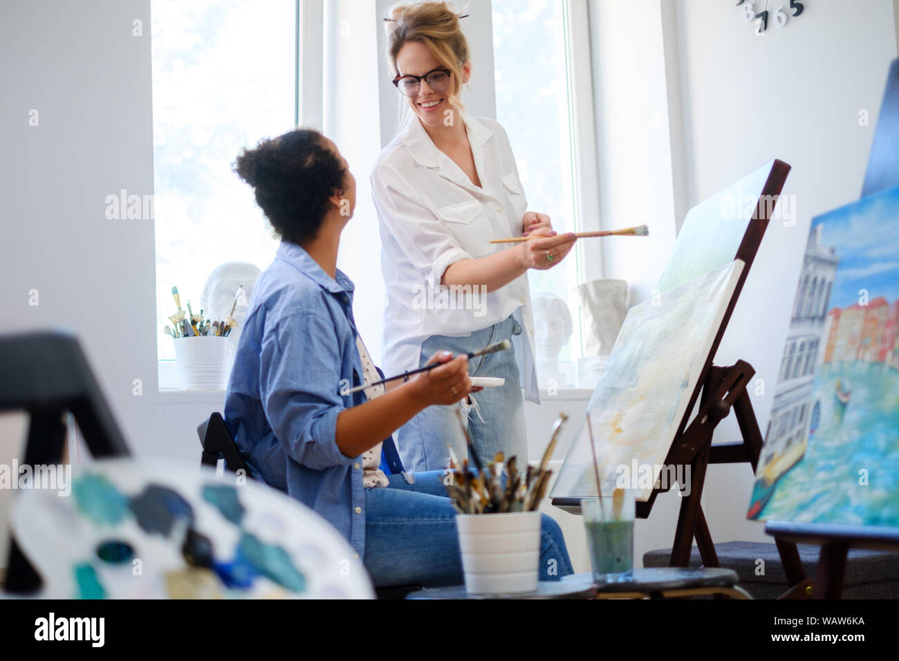 Creative painter and her protege working in a studio Stock Photo - Alamy