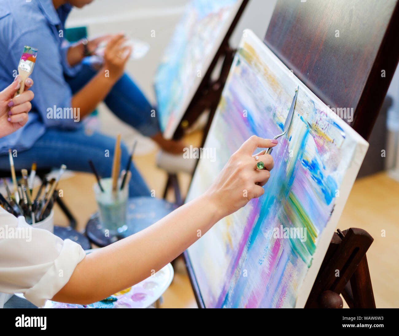 Creative painter and her protege working in a studio Stock Photo - Alamy