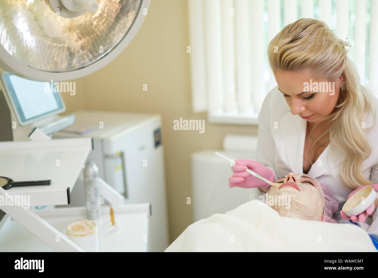 Woman cosmetologist apply cream hi-res stock photography and images - Alamy