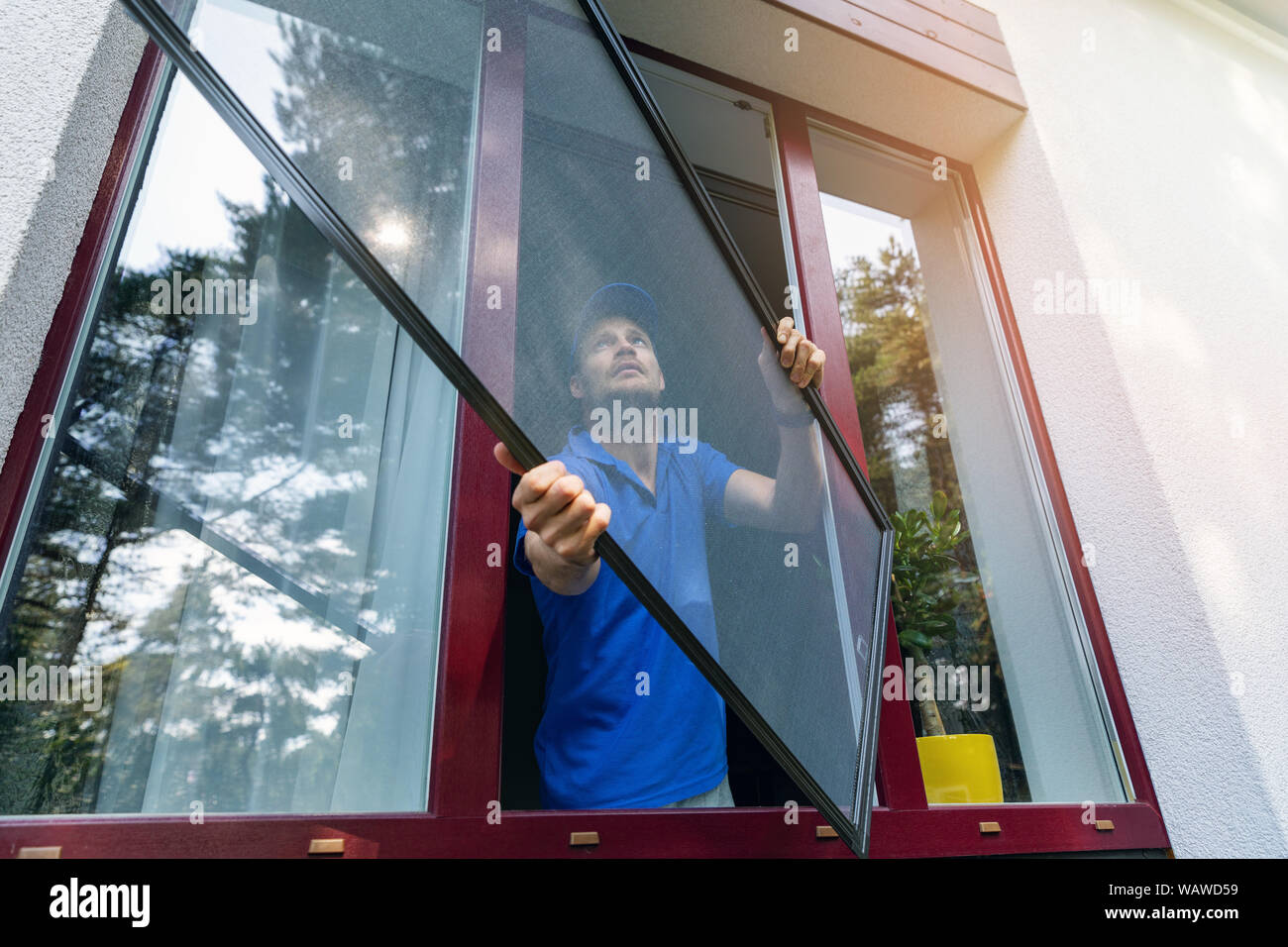 worker installing mosquito net wire screen on plastic pvc window Stock ...