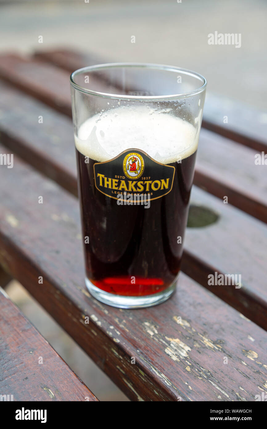 Part full pint glass of Theakston's Old Peculier beer cask real ale on ...