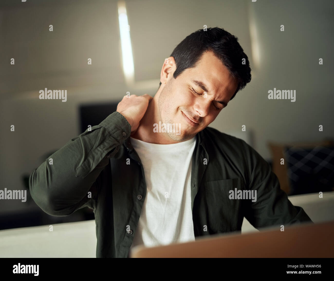 Man touching his neck with hand suffering from pain Stock Photo - Alamy
