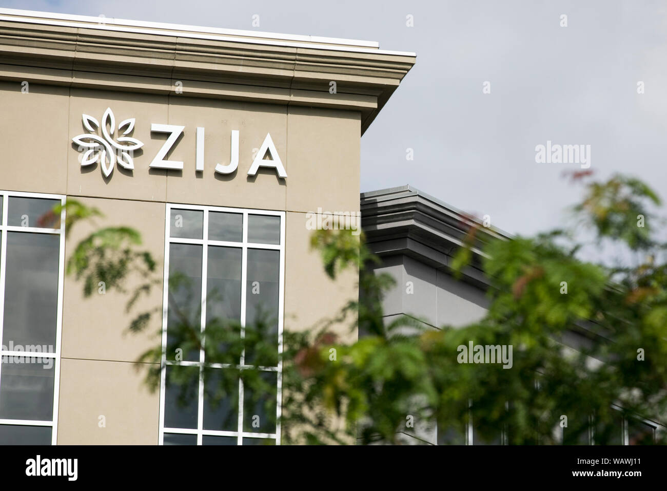 A logo sign outside of a facility occupied by Zija International in ...