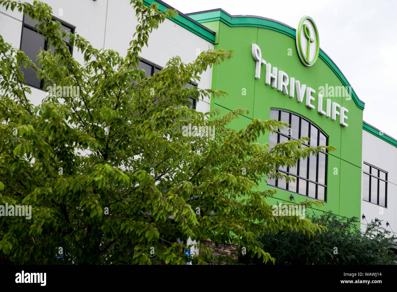 A logo sign outside of the headquarters of Thrive Life in American Fork ...