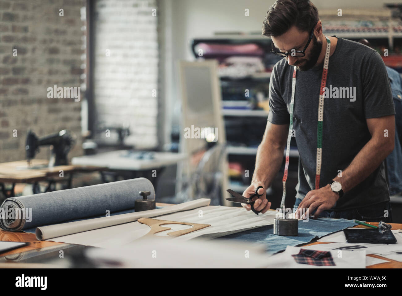 Fashion designer working in his studio Stock Photo - Alamy