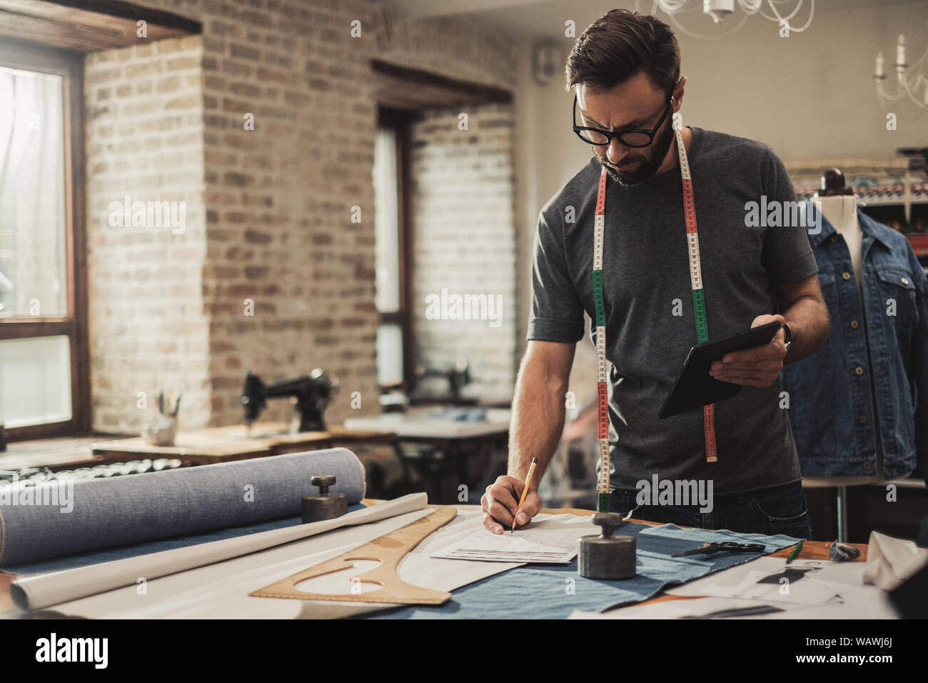 Fashion designer working in his studio Stock Photo - Alamy