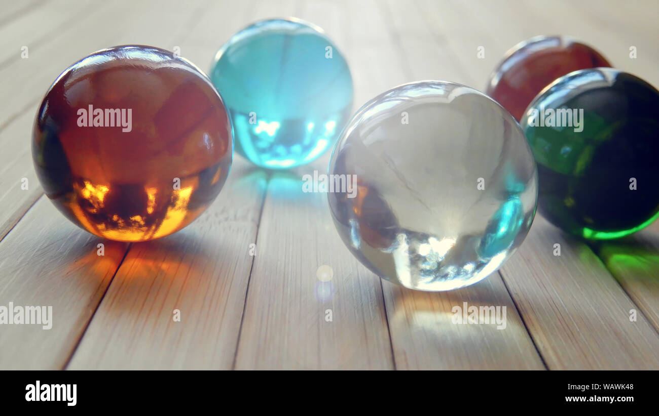 Still life photography of five colorful glass balls in the sunny beams ...