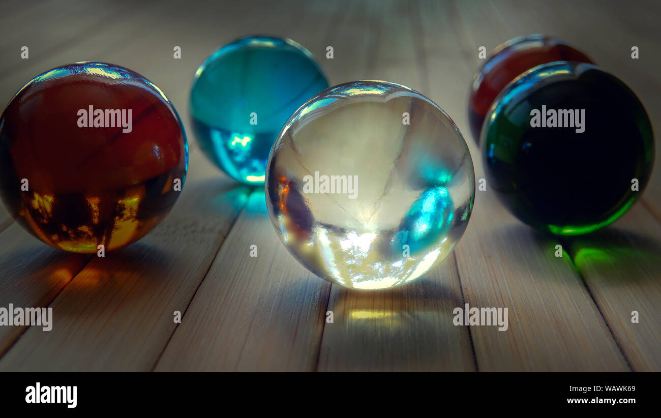Still life photography of five colorful glass balls in the sunny beams ...