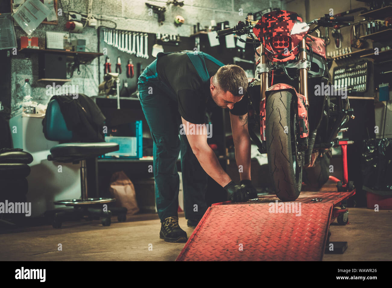 Mechanic arepairing a motorcycle in a workshop Stock Photo - Alamy