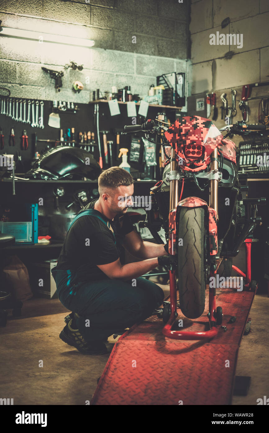Mechanic arepairing a motorcycle in a workshop Stock Photo - Alamy