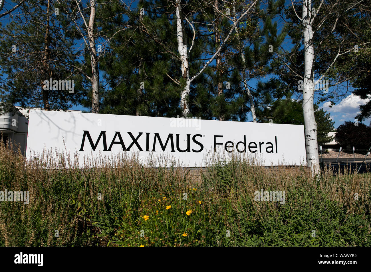 A logo sign outside of a facility occupied by MAXIMUS Federal in Sandy ...
