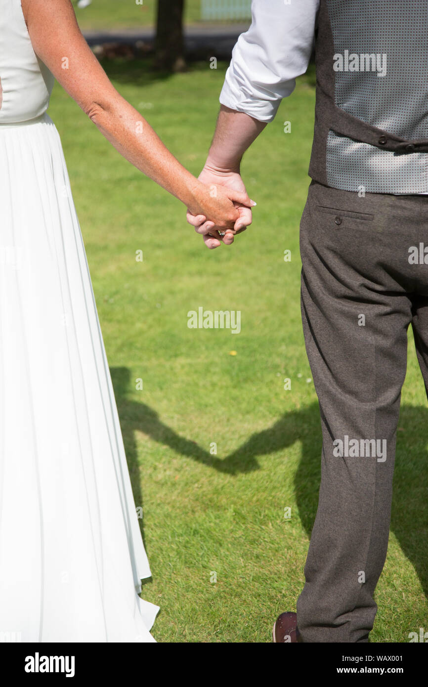 Bride and grooms hands on their wedding day, close up of Bride and ...