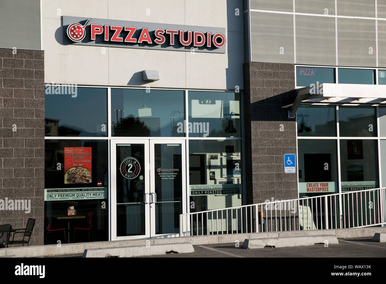 A logo sign outside of a Pizza Studio restaurant location in Lehi, Utah ...