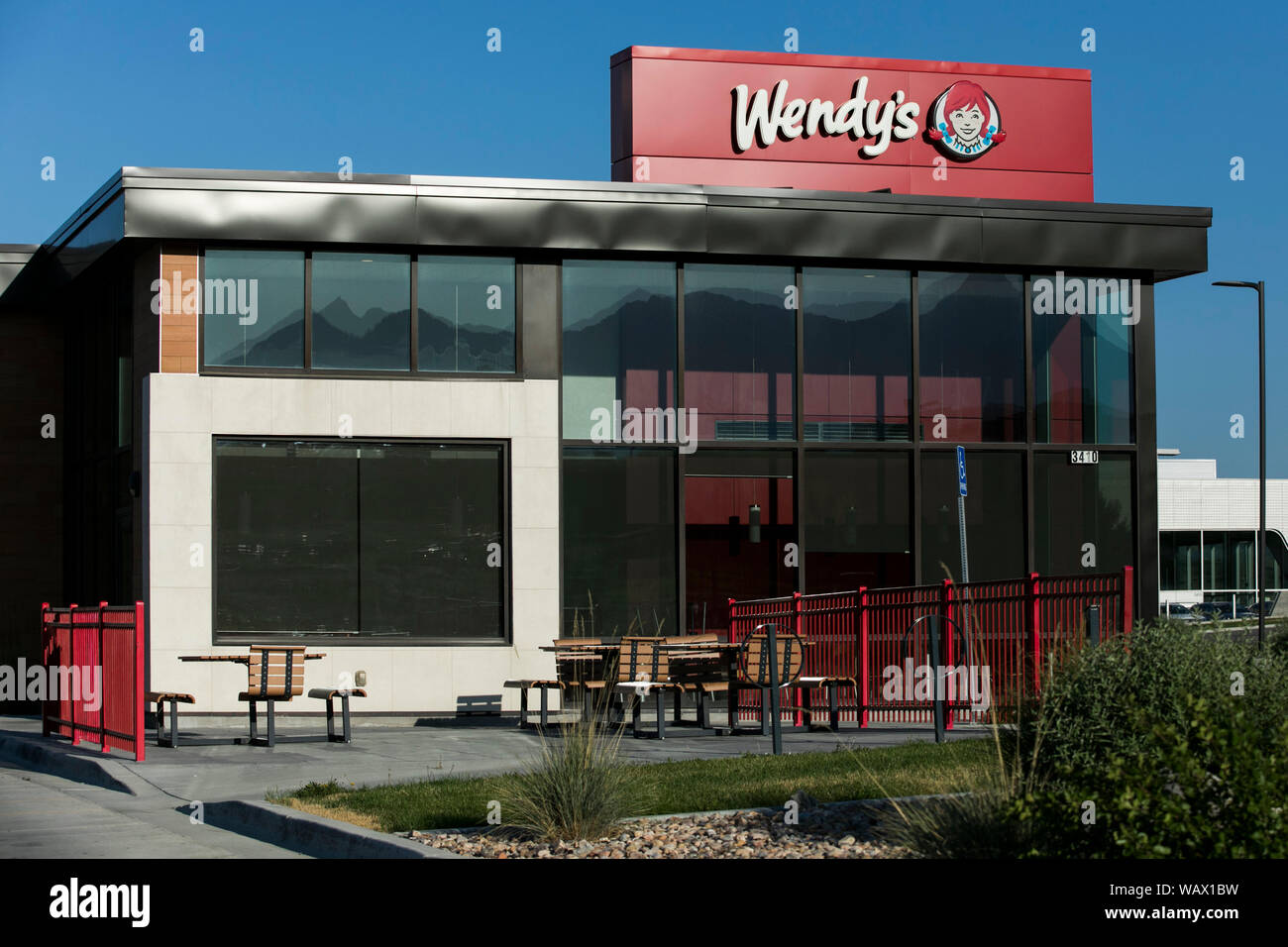 A logo sign outside of a Wendy's fast food restaurant location in Lehi ...