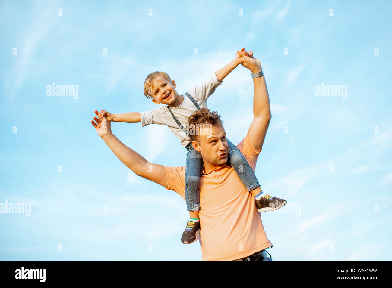 Portrait of a happy father with young son riding on the shoulders on ...