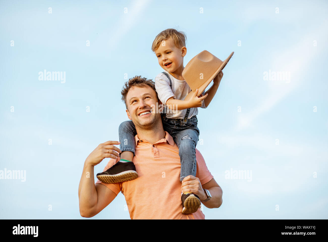 Portrait of a happy father with young son riding on the shoulders on ...
