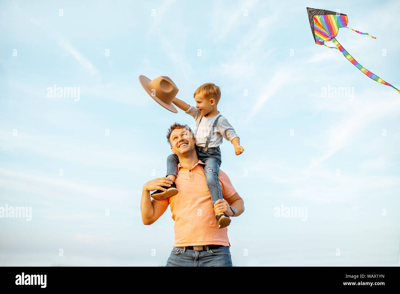 Portrait of a happy father with young son riding on the shoulders on ...