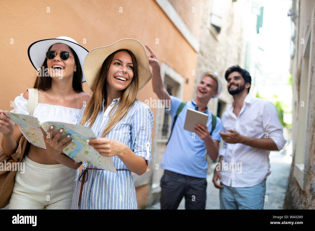Group of friends tourists with map in old city on vacation Stock Photo ...