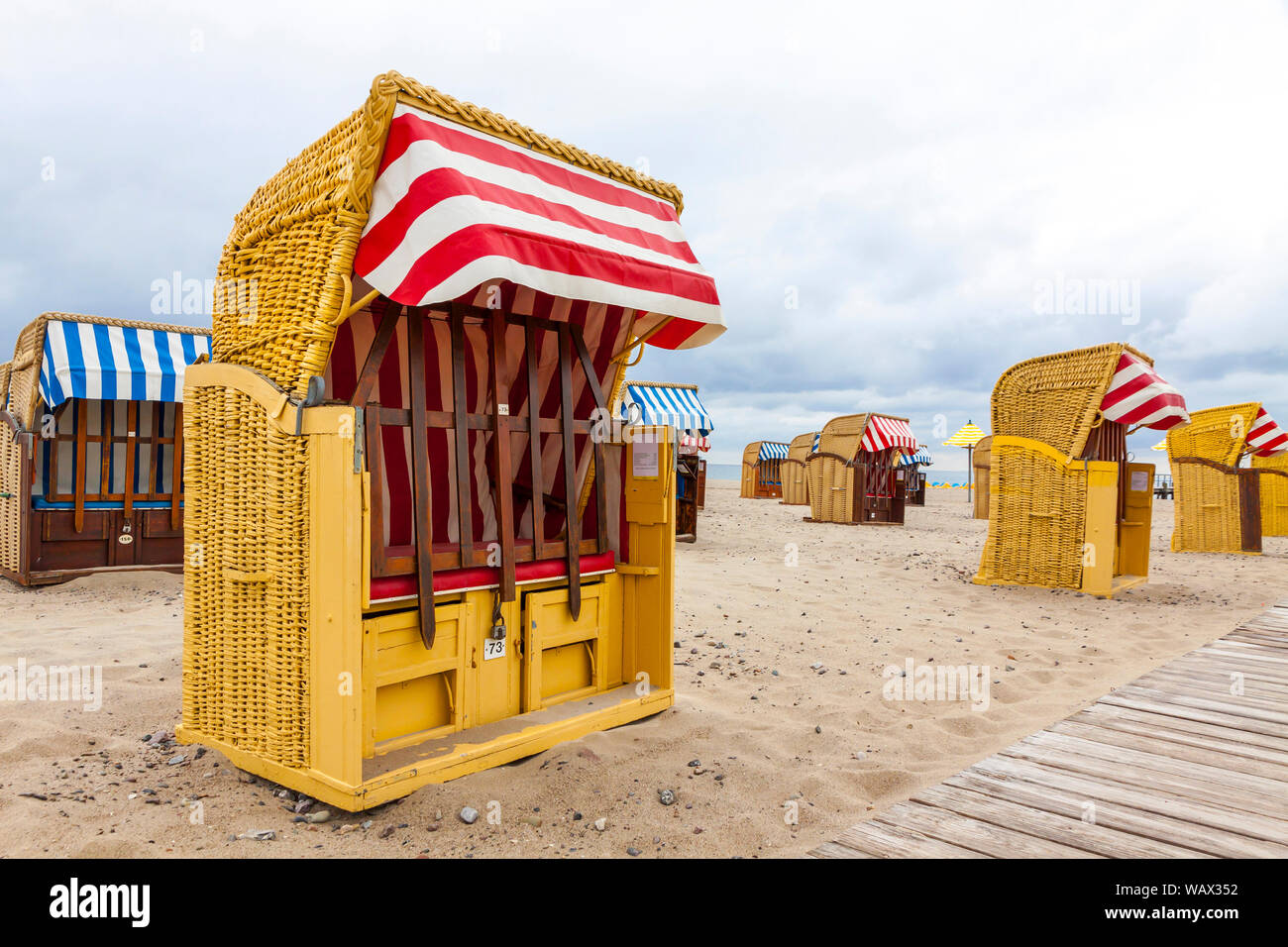 Strandkorb - colorful striped wooden hooded beach chairs. Sandy Baltic ...
