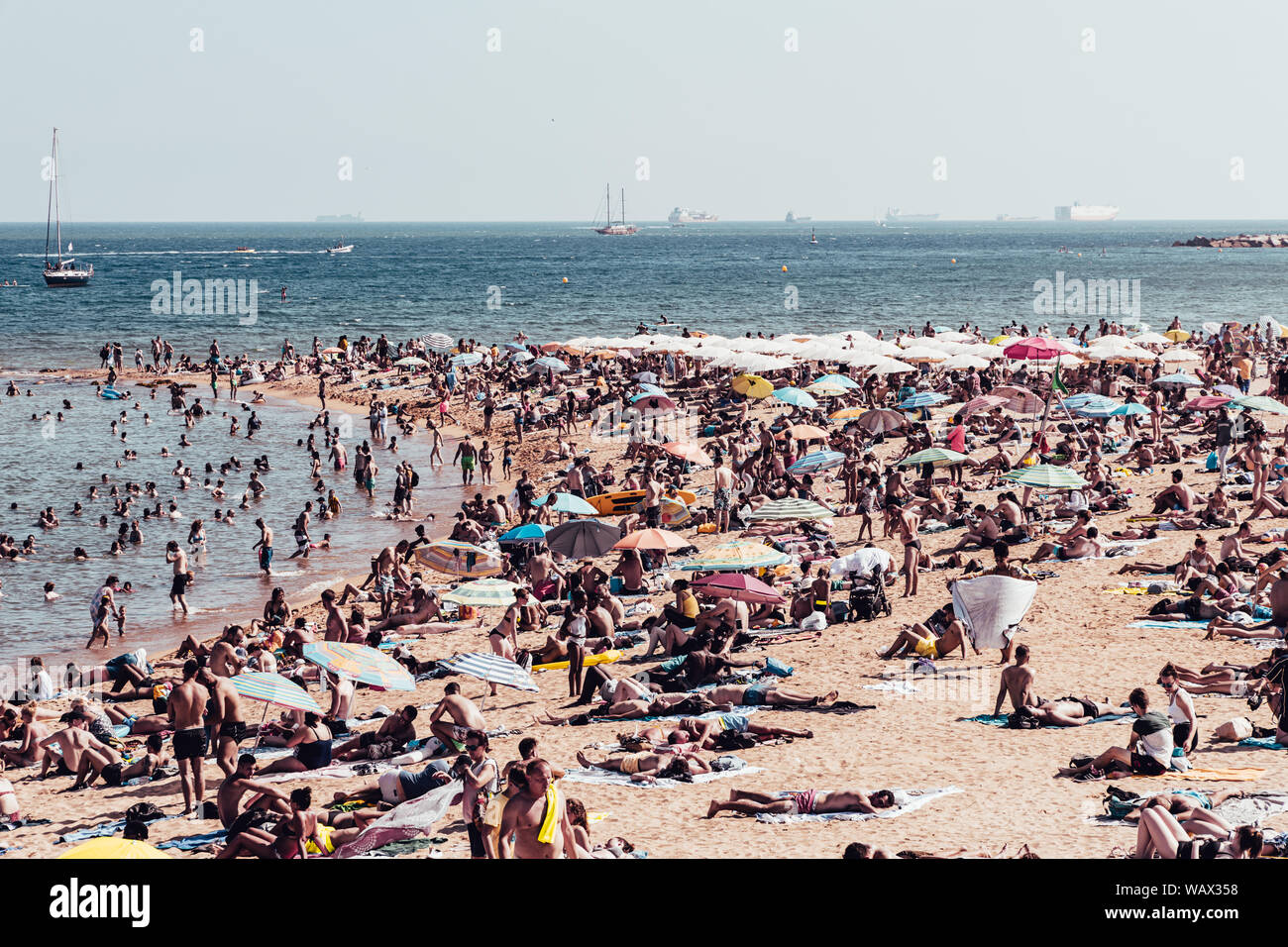 BARCELONA, SPAIN - AUGUST 8, 2019: People on crowded busy beach on hot ...