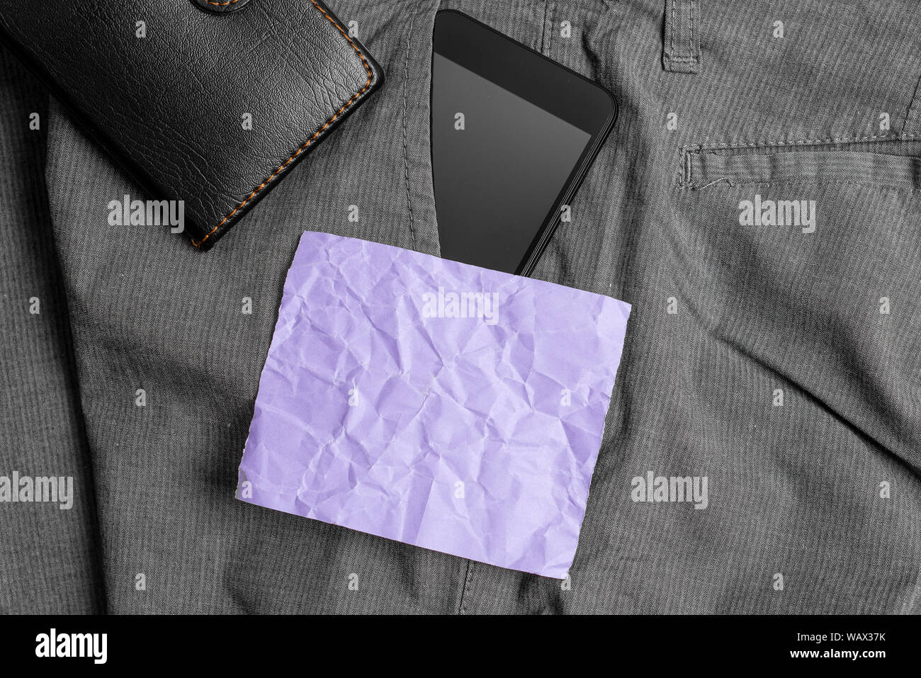 Smartphone device inside trousers front pocket with wallet and note ...