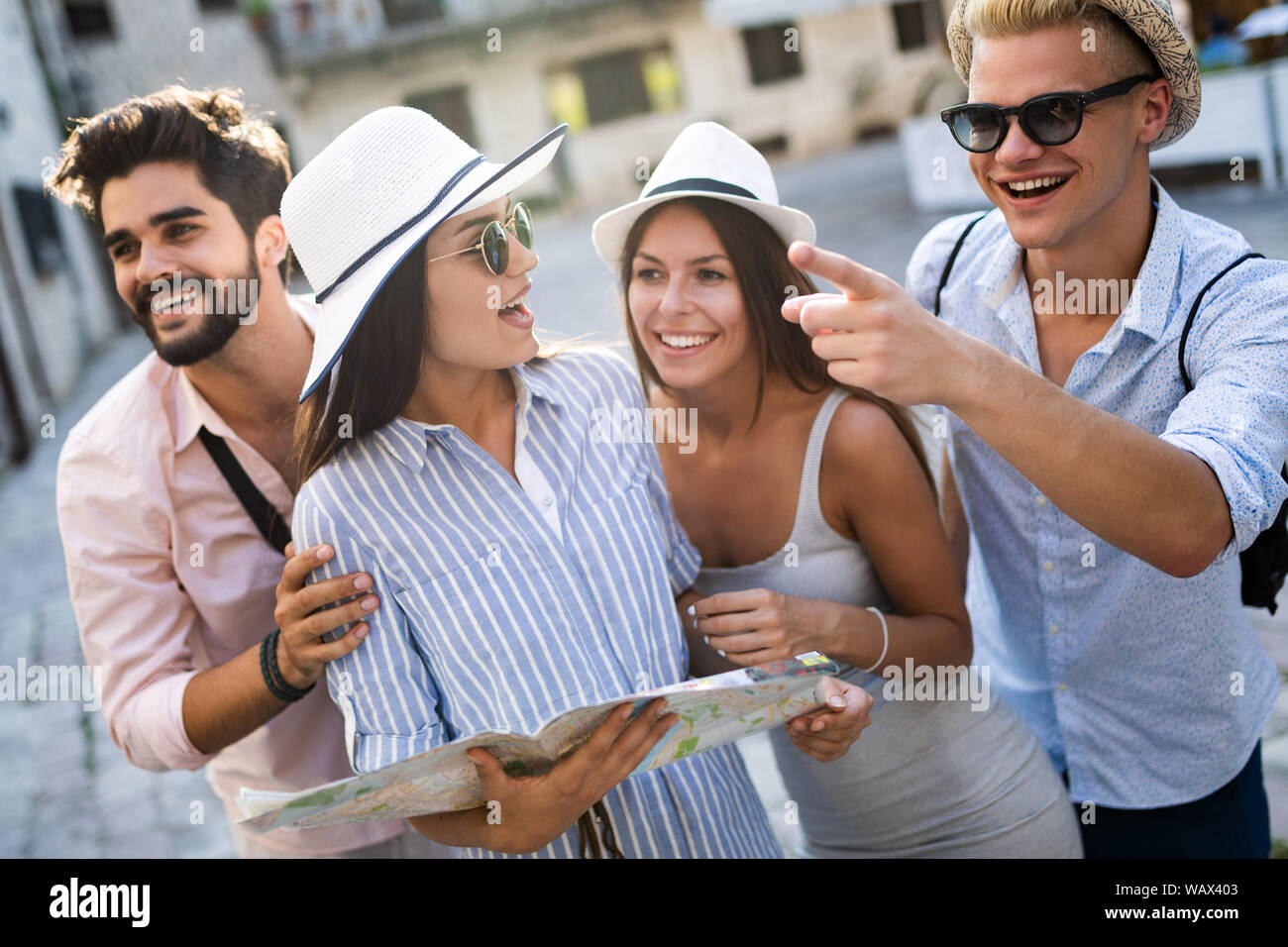 Happy group of tourists traveling and sightseeing together at summer ...
