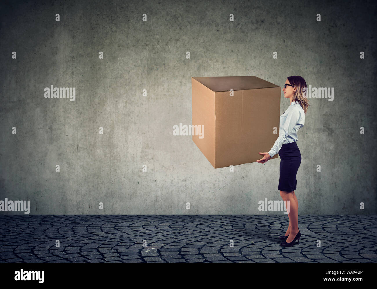 Businesswoman carrying a huge box Stock Photo - Alamy