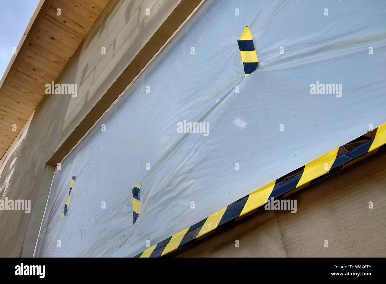 Window of a house under construction covered with protective plastic ...