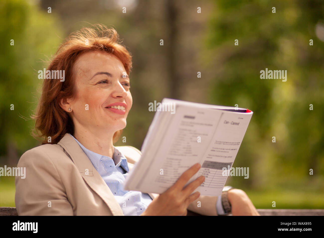 woman laughing while reading a book Stock Photo - Alamy