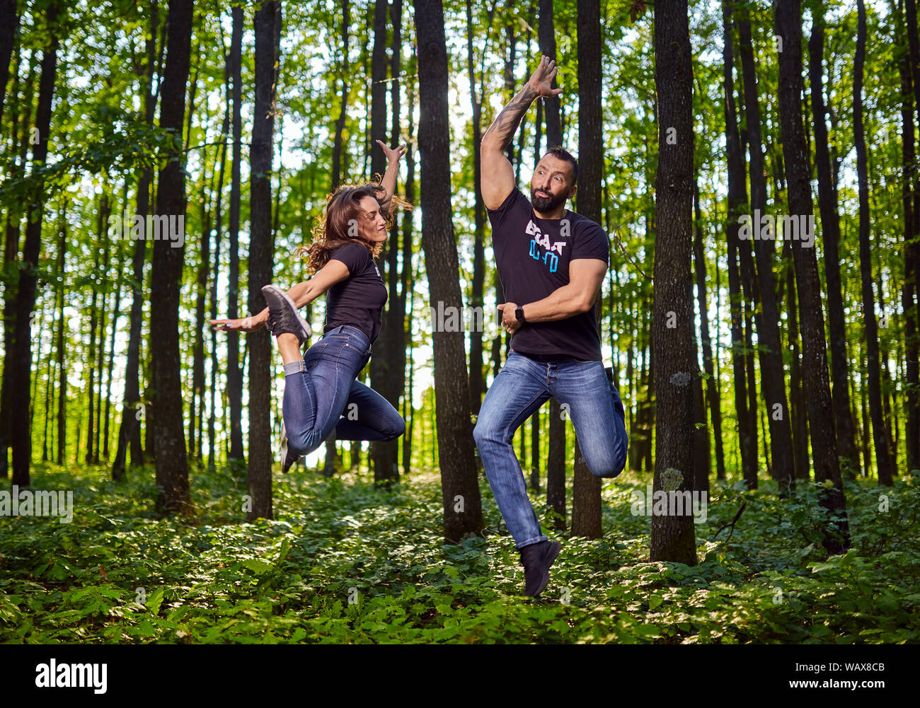 Funny couple jumping for joy Stock Photo - Alamy