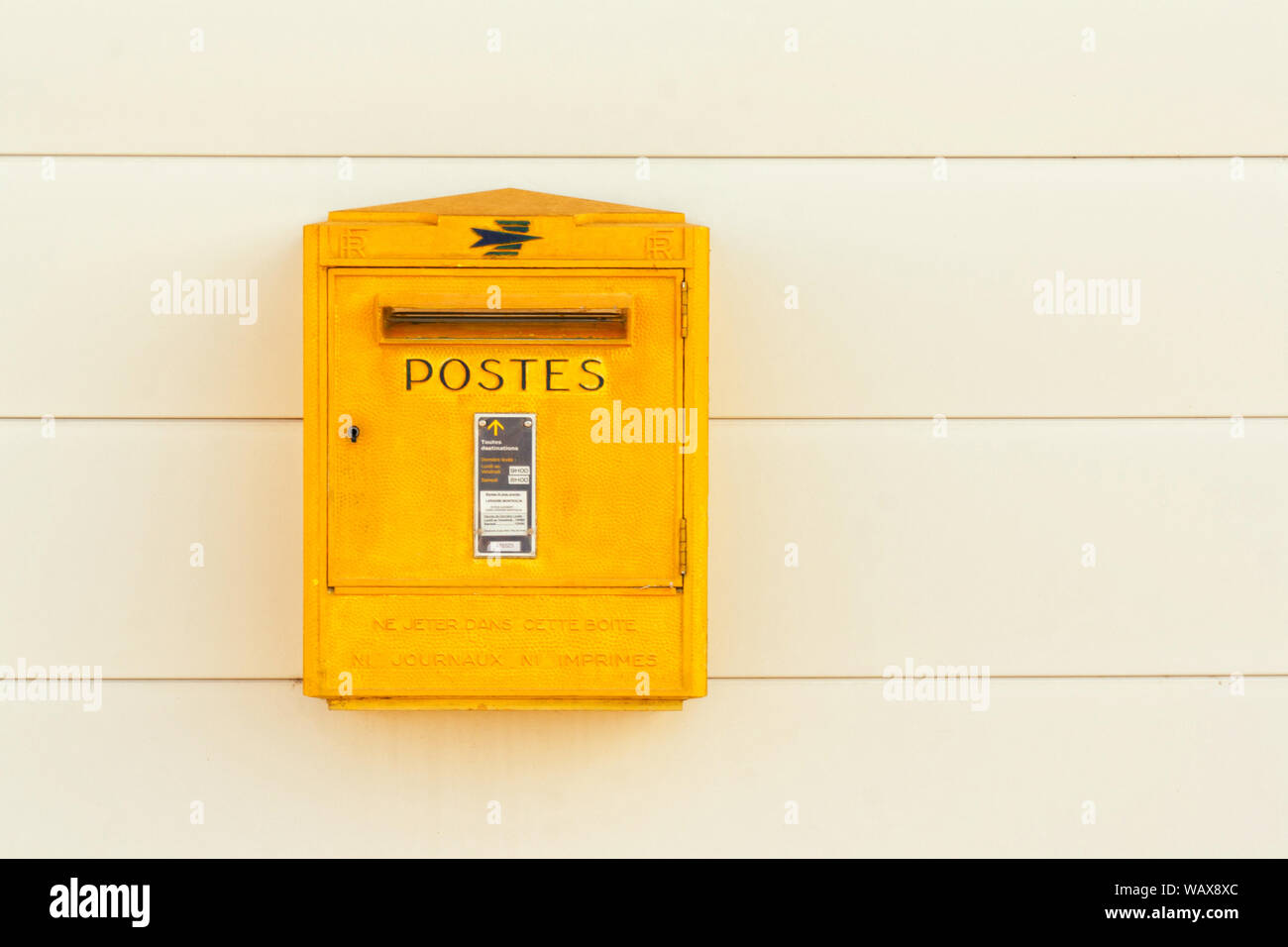 Yellow french postal services mailbox on a white wall Stock Photo - Alamy
