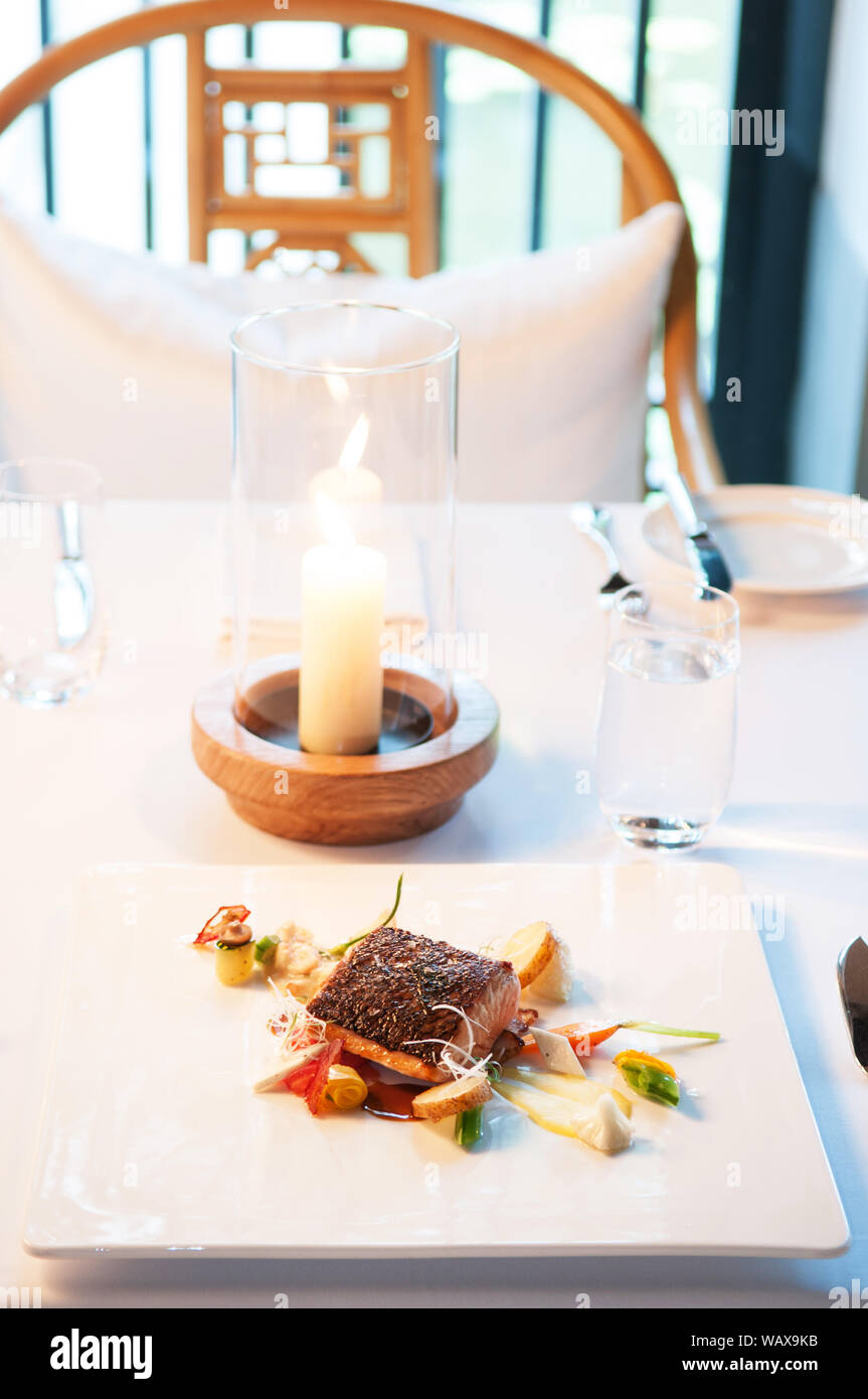 Grilled fish with grilled vegetables dish on dinner table Stock Photo ...