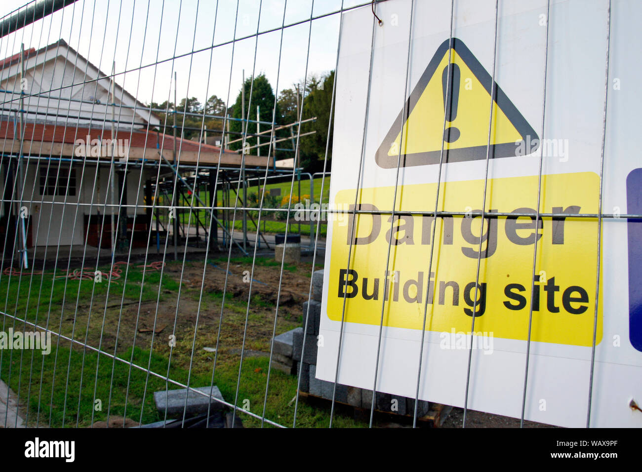 Yellow and white sign saying Danger Building site Stock Photo - Alamy
