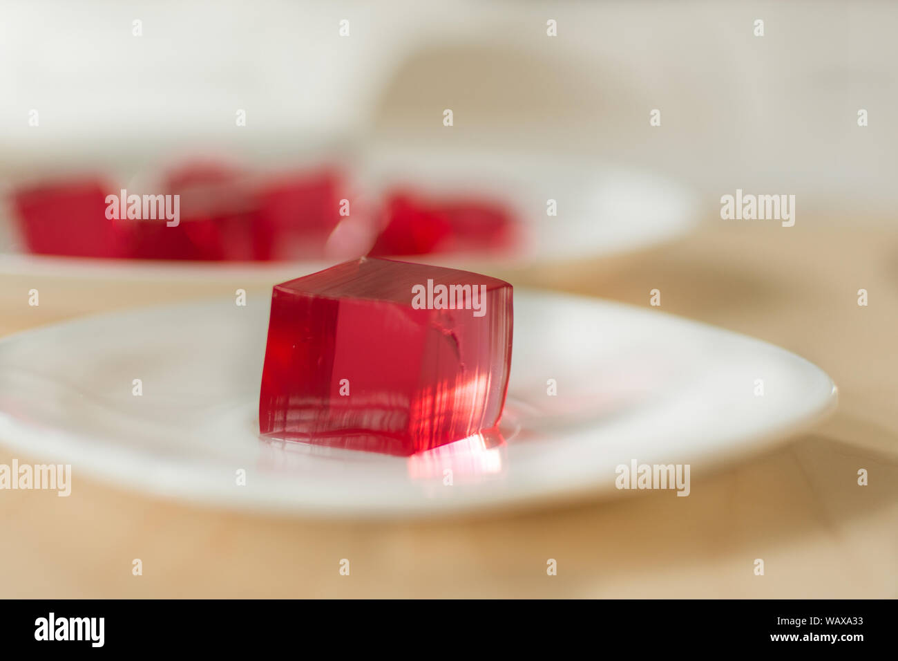 Red jelly cubes on white plate background. Berry sweet pieces of jelly ...