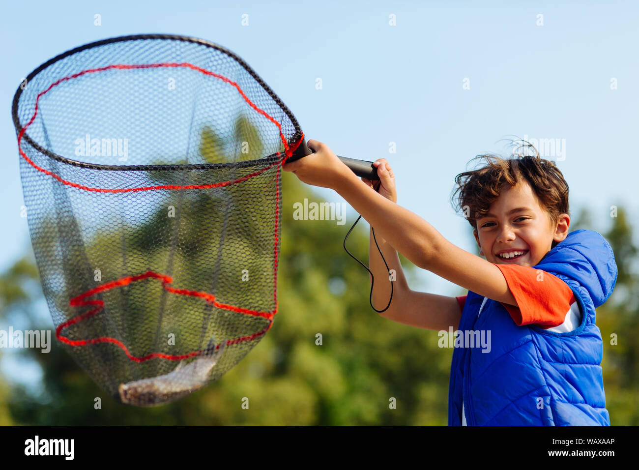 Boy holding fishing net fish hi-res stock photography and images - Alamy