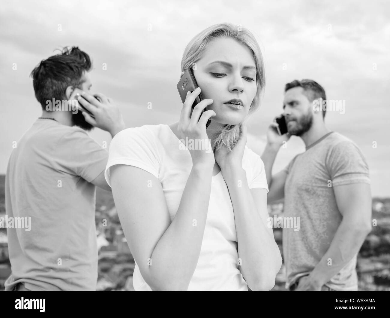 Using the mobile technology while on the move. Group of friends talk on ...