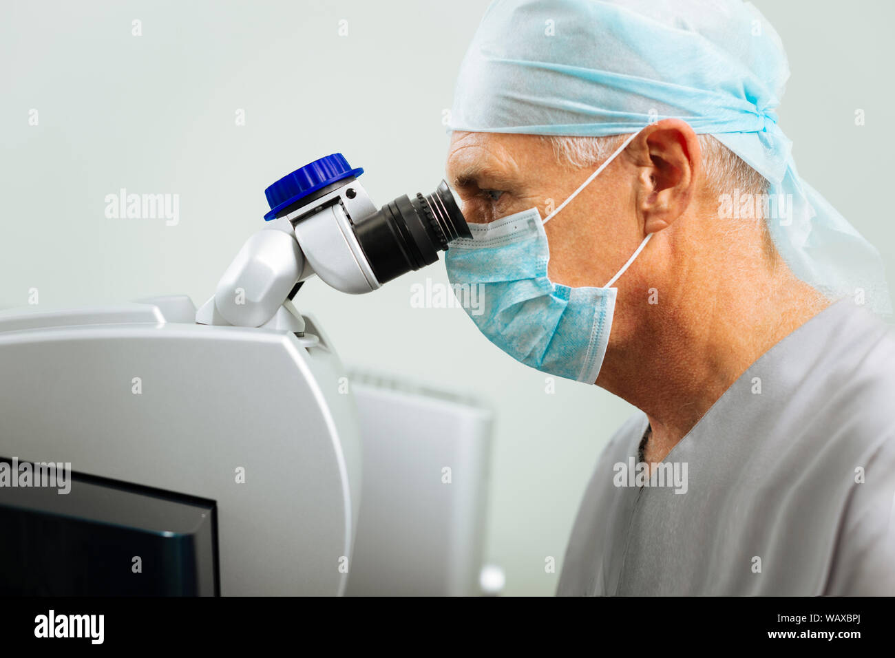 Smart serious doctor looking into the microscope Stock Photo - Alamy