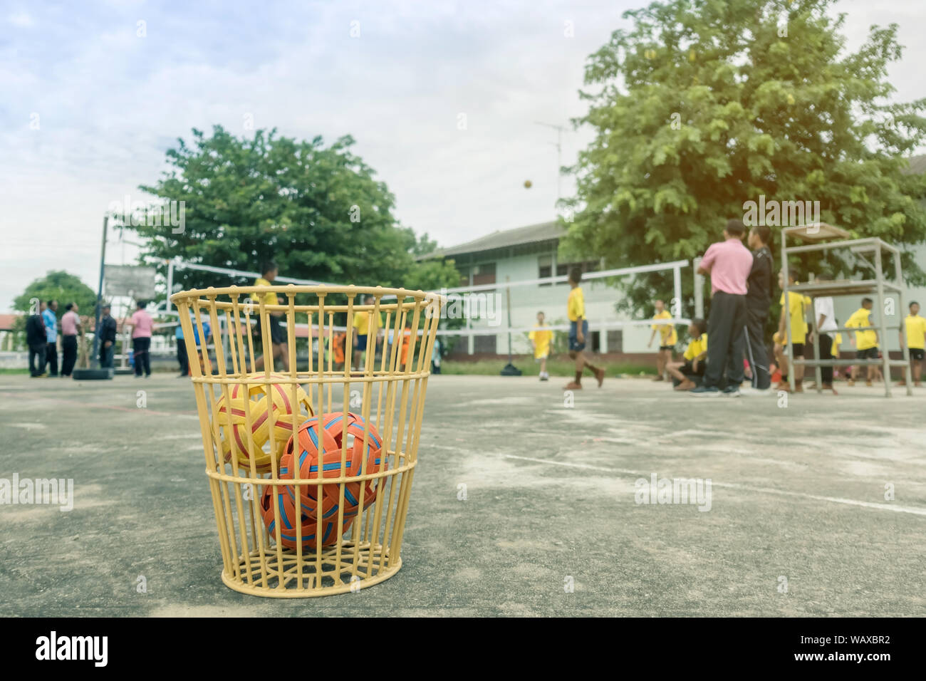 The takraws in the plastic basket on the cement floor beside the field ...
