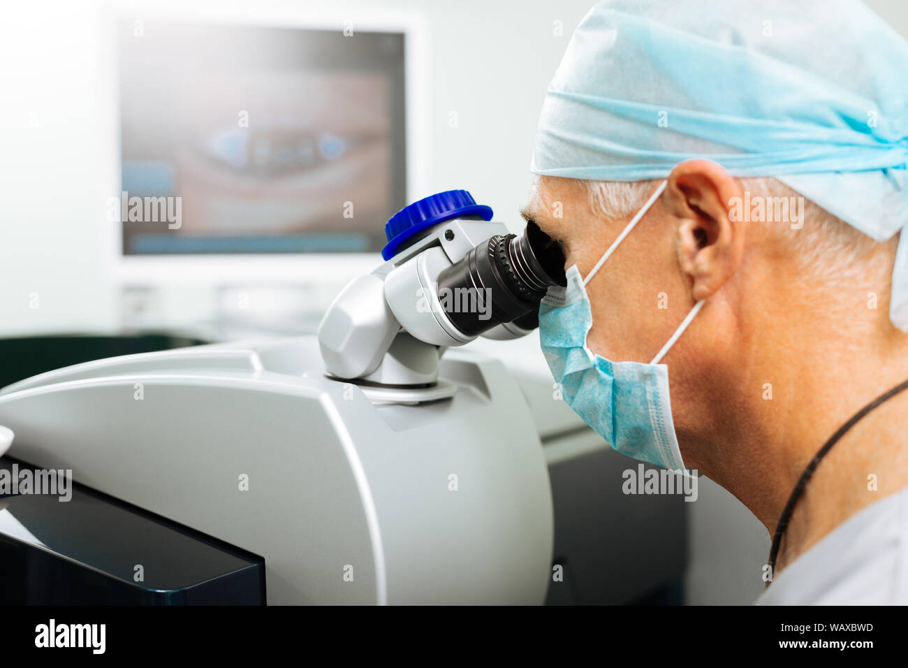 Professional serious doctor using the microscope for work Stock Photo ...