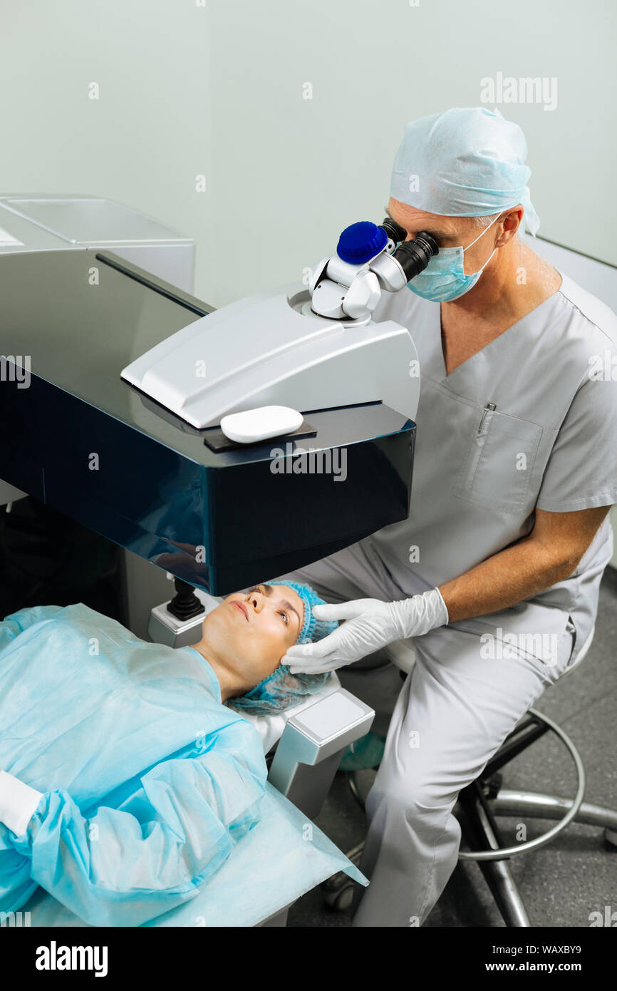 Professional smart doctor keeping the patients head fixed Stock Photo ...