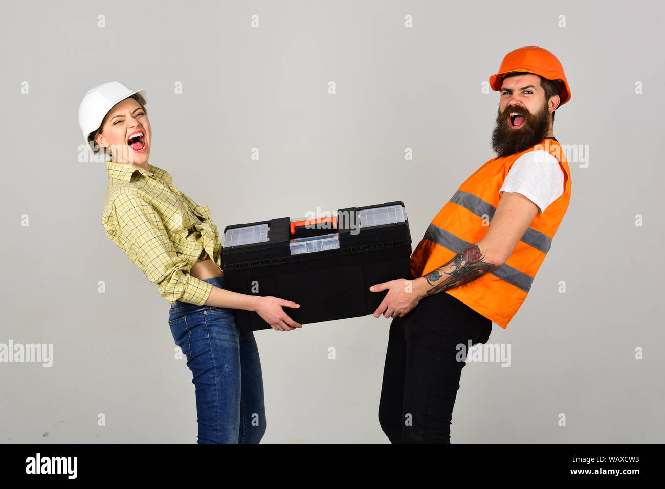 Builders with toolbox, couple in love makes repair grey background ...