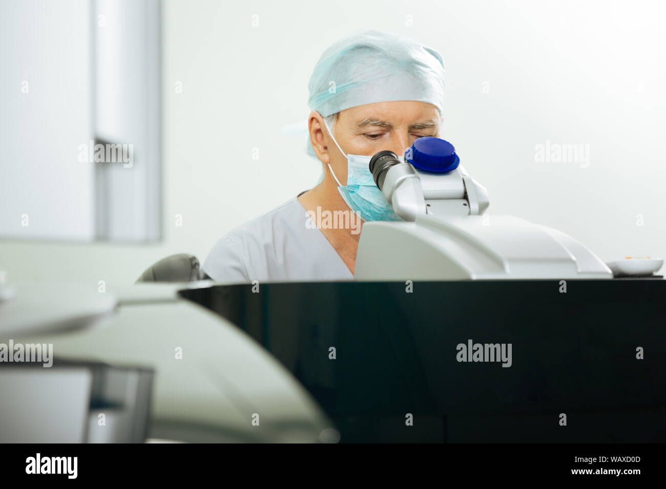 Serious focused eye doctor concentrating on his work Stock Photo - Alamy
