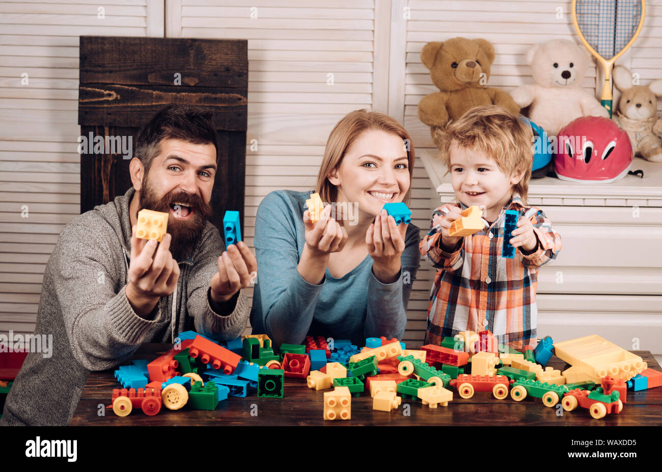 Young family play game with construction blocks. Father, mother and son ...