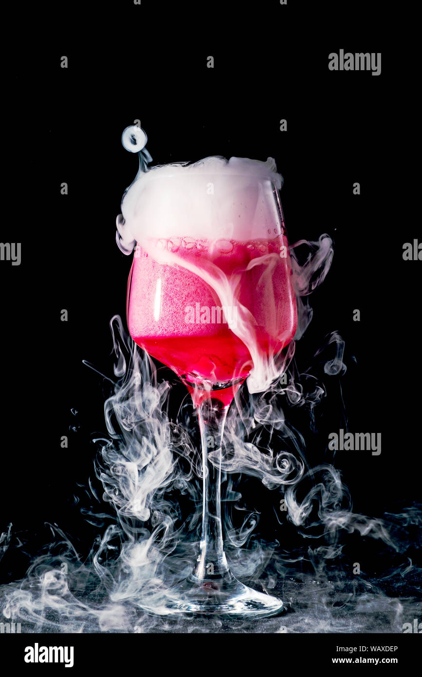 Glass with pink drink and dry ice smoke, bubbles, background Stock ...