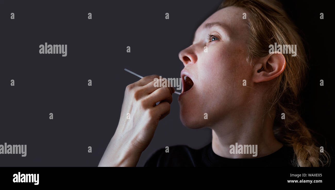 Woman doing DNA test with cotton swab at home. Test for home use ...