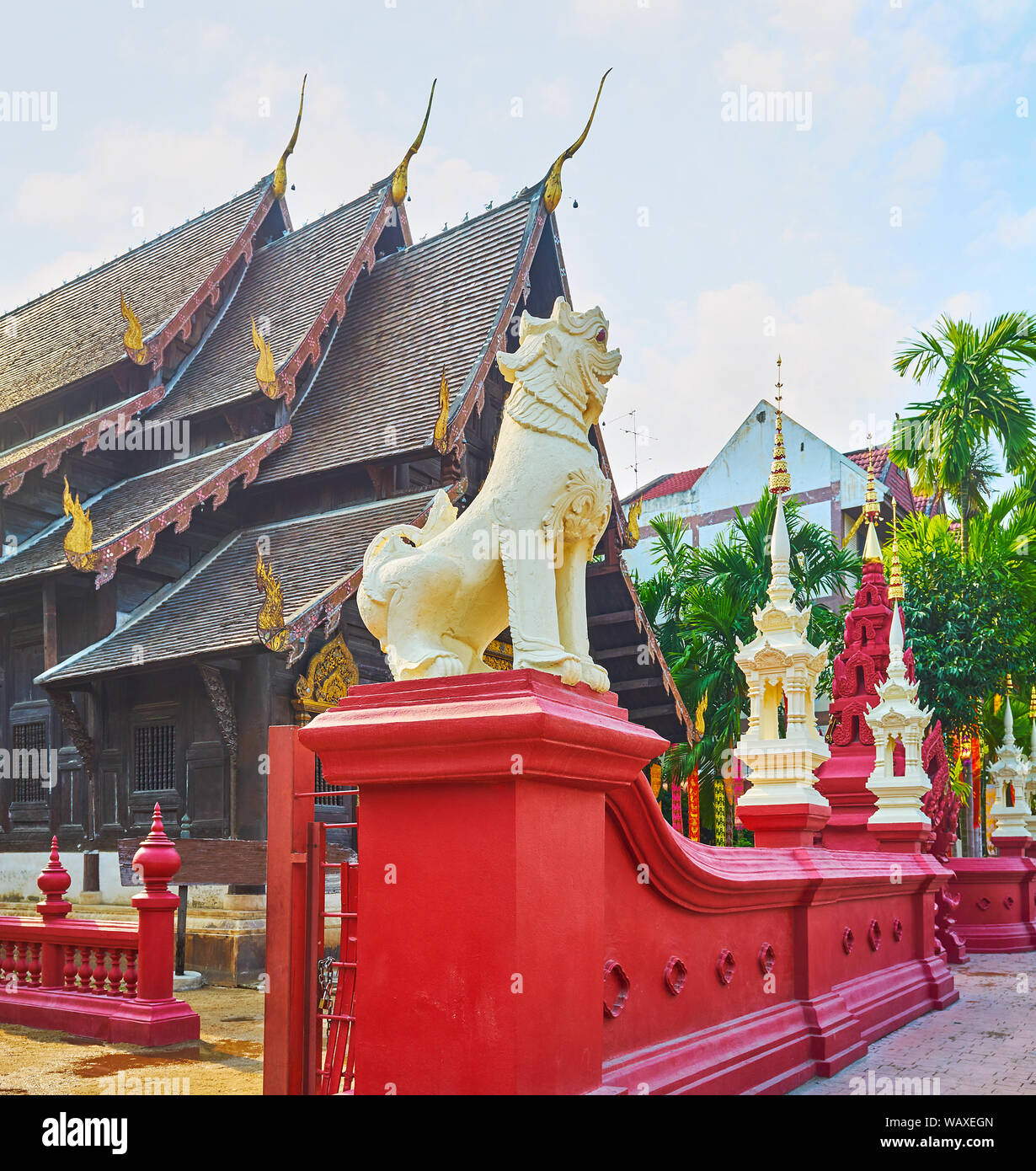 The red fence of Wat Phan Tao is topped with plaster sculpture of ...