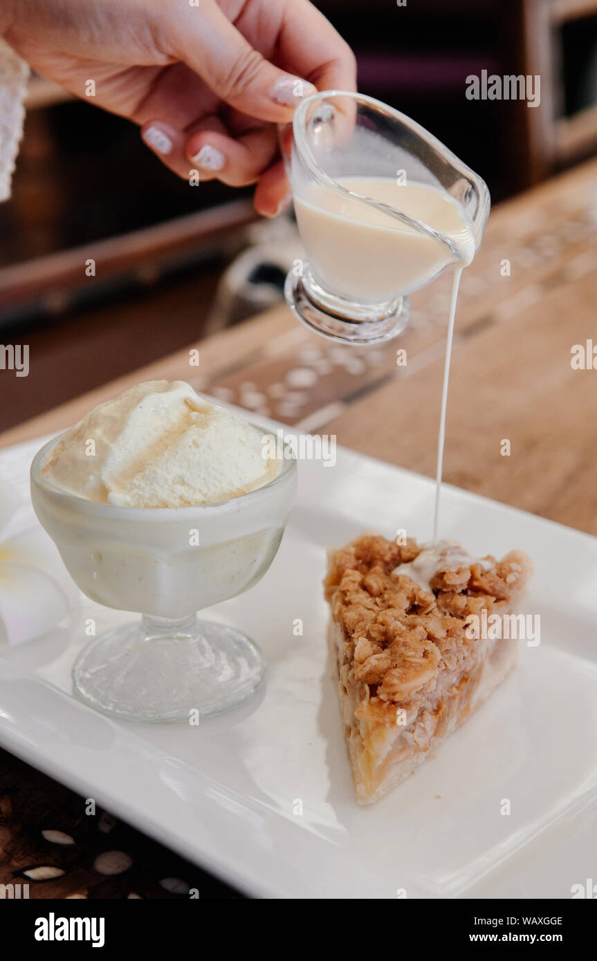Woman pouring cream on apple cake hi-res stock photography and images ...