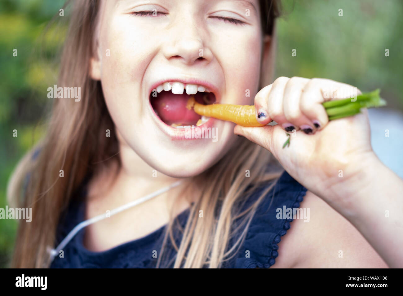 Girl eating carrot. Child face closeup. Healthy, organic food. Fresh ...