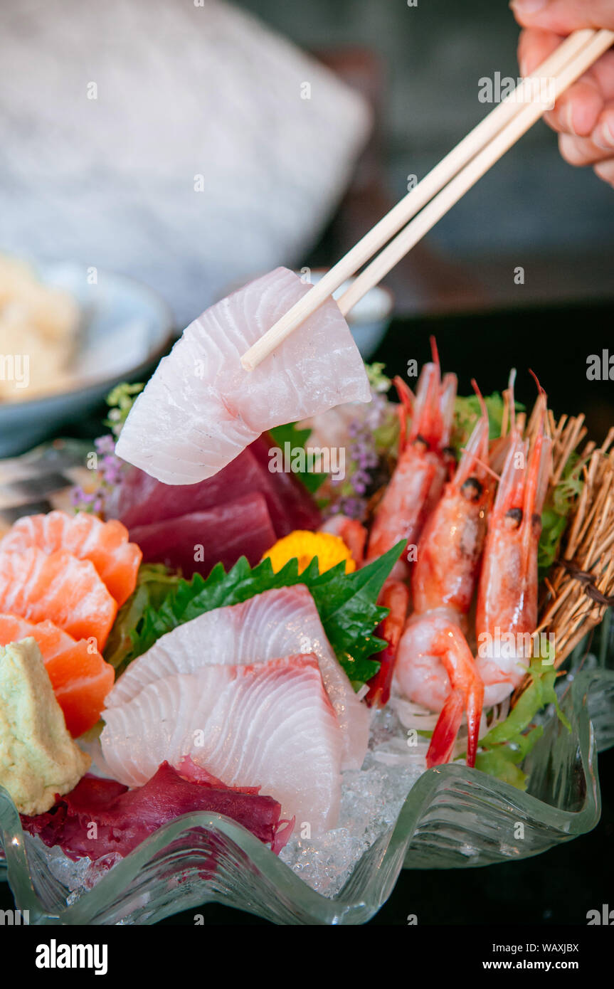 Picking Premiwith chopstick, Tai fish sashimi, Ebi sashimi, Maguro ...