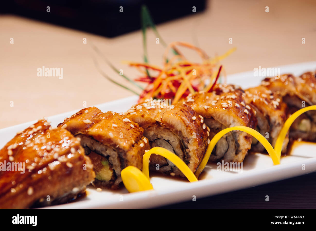 Beautiful pieces of Japanese grilled Unagi Maki roll on white plate ...